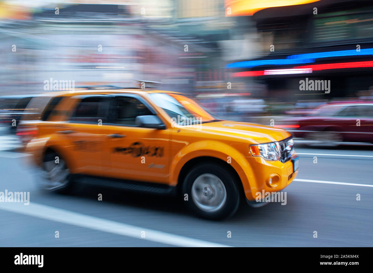 Yellow New York taxi cab driving fast on a street in New York City, USA ...