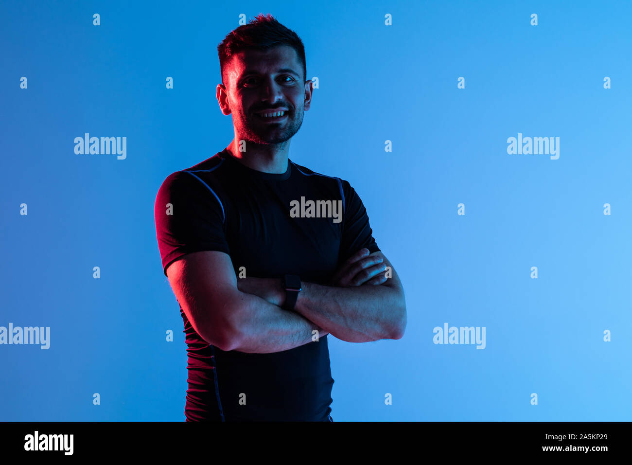 Portrait of a smiling muscular man standing with arms folded Stock ...