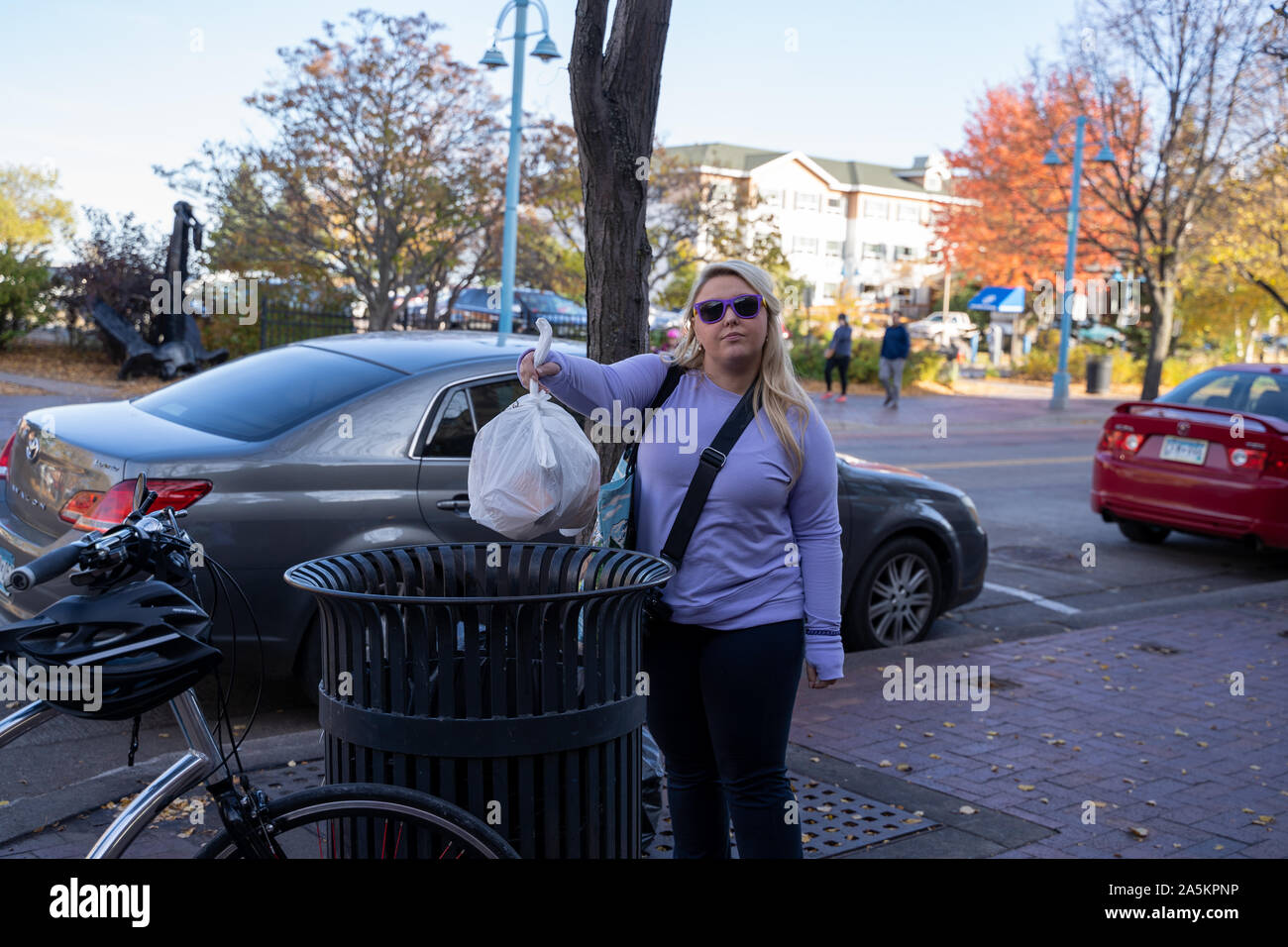 Duluth, Minnesota - October 20, 2019: Adult woman throws a bag of trash ...