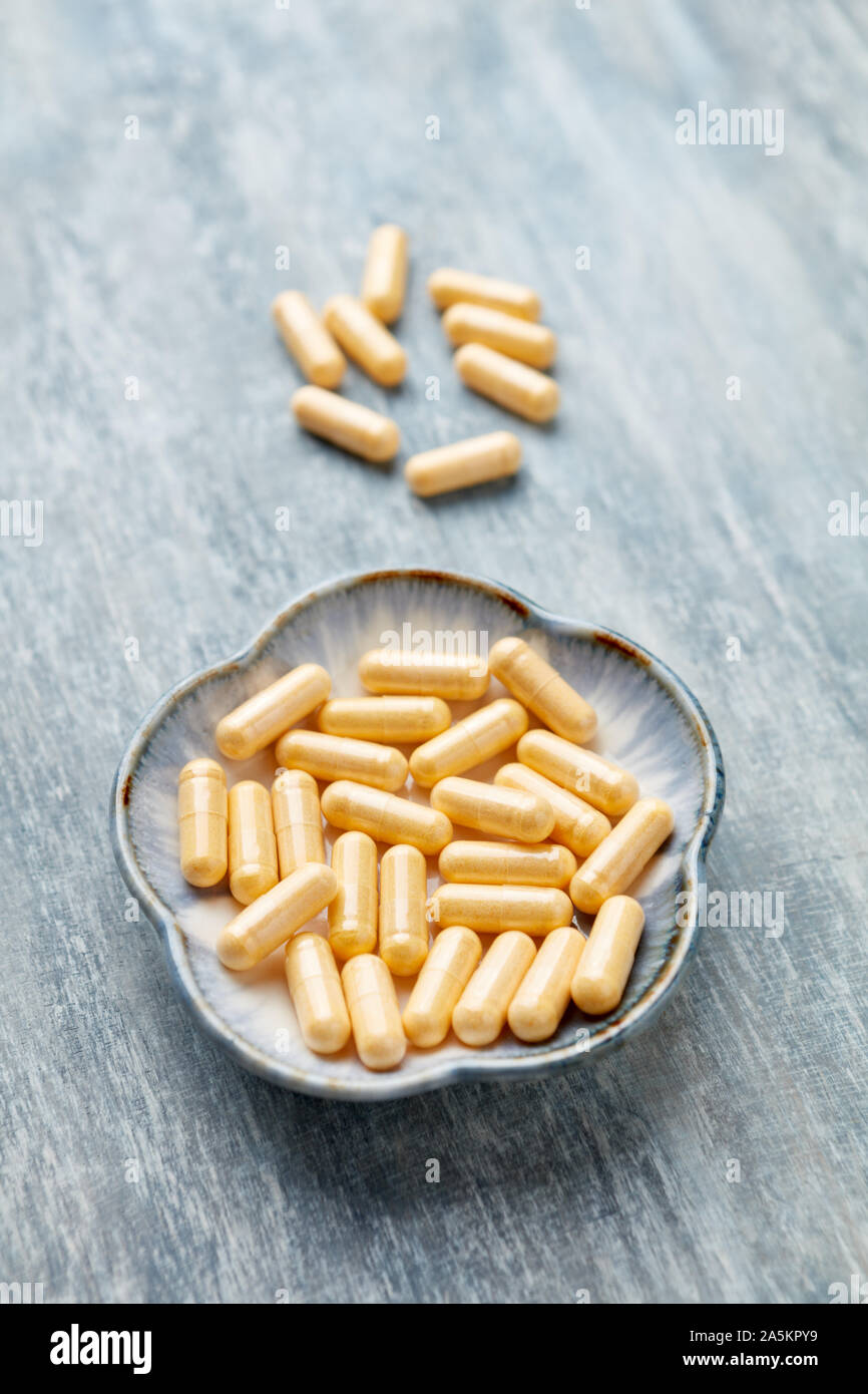 Coenzyme Q10 capsules. Dietary supplements. Rustic wooden background ...