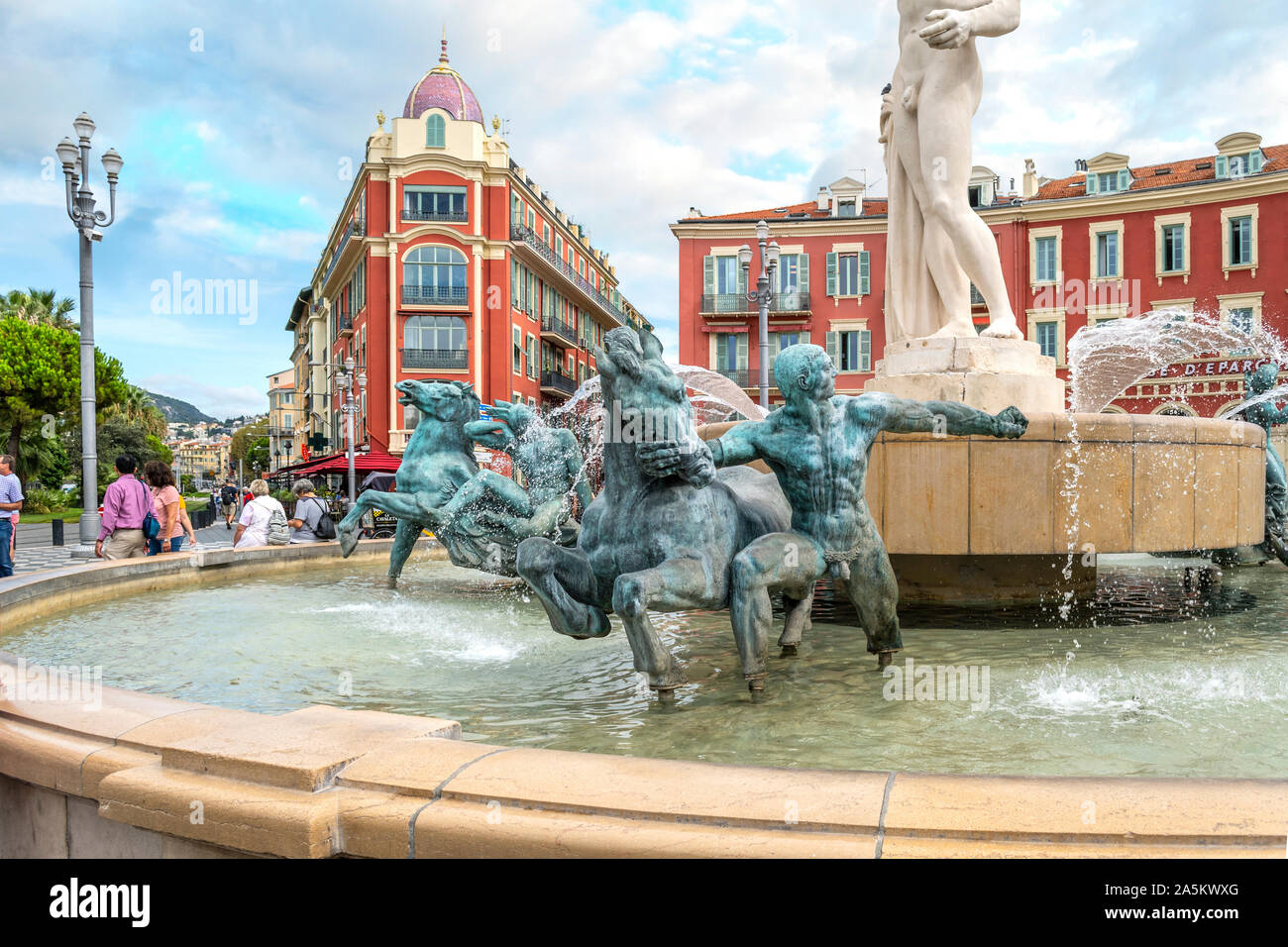 Tourists pass by the Fountain of the Sun with Roman God Apollo at Place ...