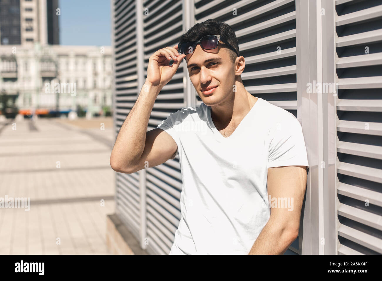 Outdoors Leisure. Stylish guy standing on the street leaning back ...