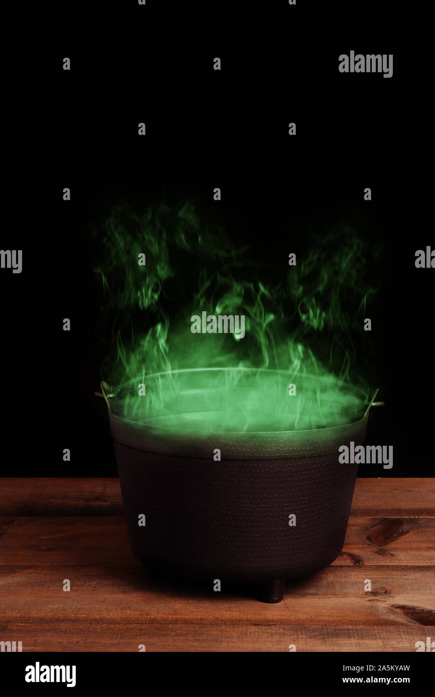 black halloween cauldron with green smoke Stock Photo - Alamy