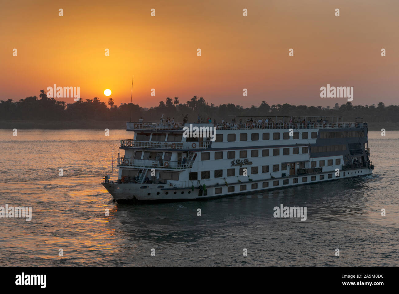 River Nile Cruise ships approach Kom Ombo with the sun setting over the ...