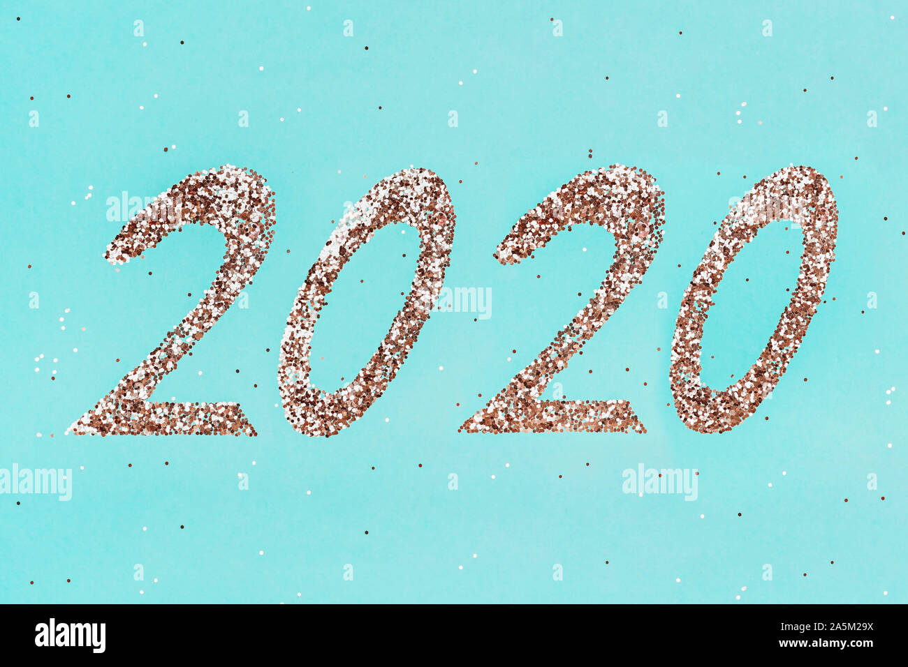 Golden sparkles shaped 2020 on green mint background Stock Photo - Alamy