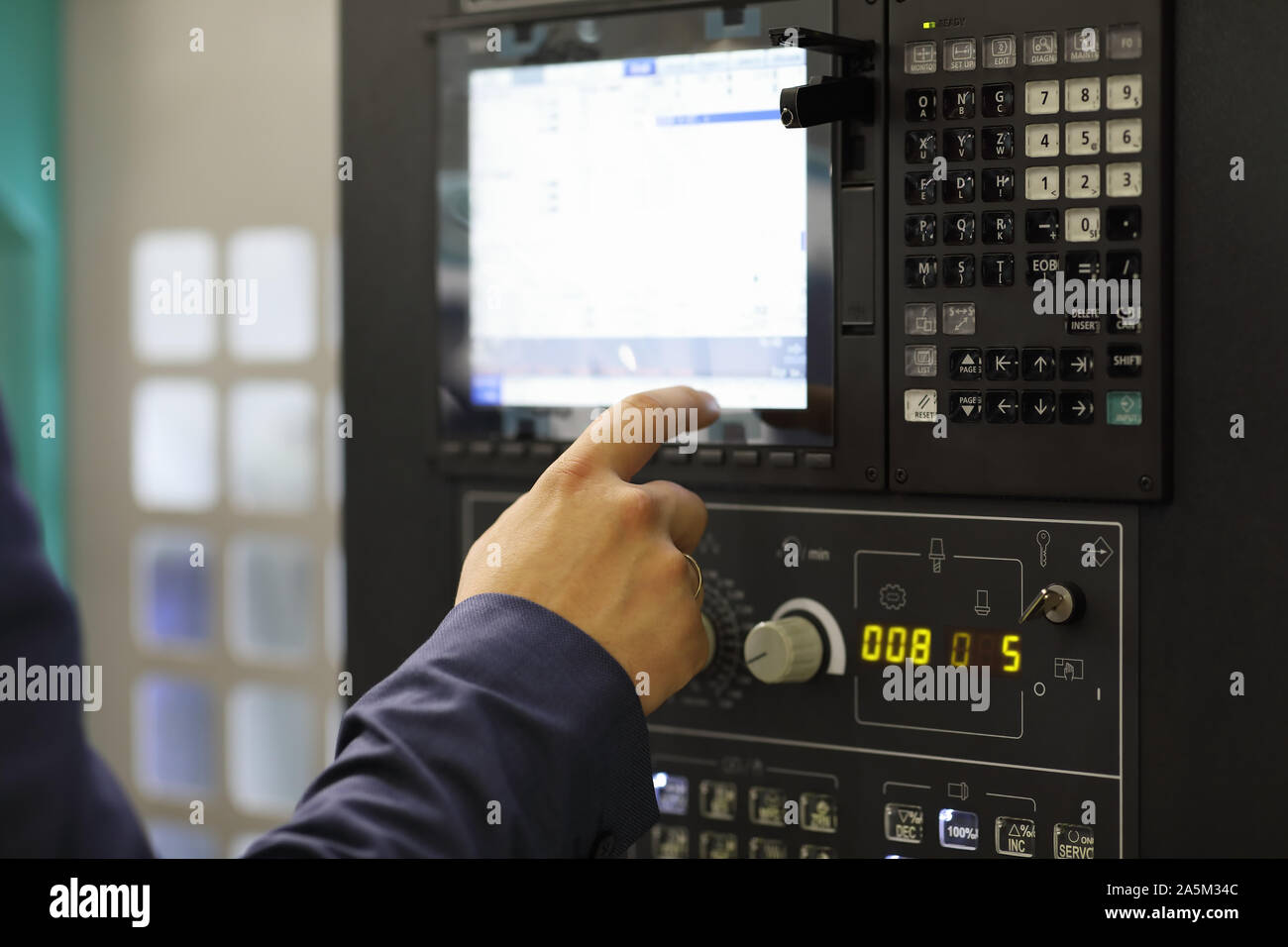Engineer working with touchscreen on control panel of CNC machining ...