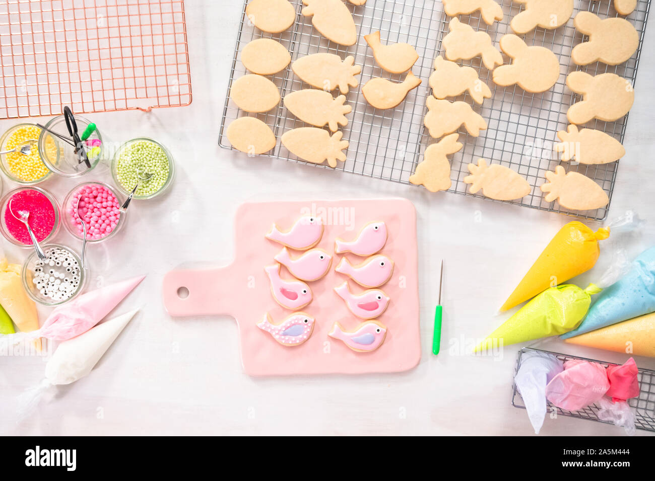 Flat lay. Decorating Easter sugar cookies with rotal icing Stock Photo ...