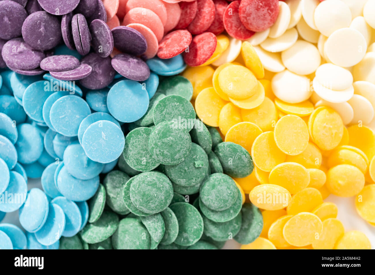 Rainbow colors of round chocolate chips for melting chocolate shapes on ...