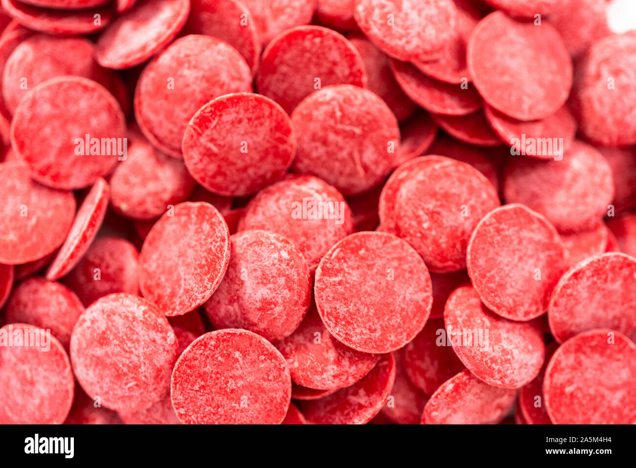 Red round chocolate chips for melting chocolate shapes on a white ...