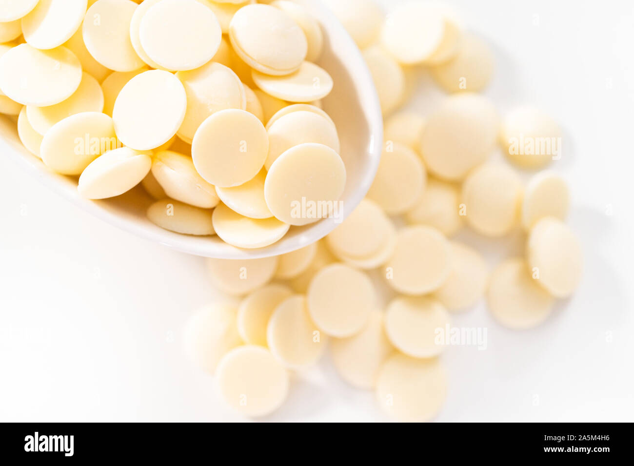 White round chocolate chips for melting chocolate shapes on a white ...