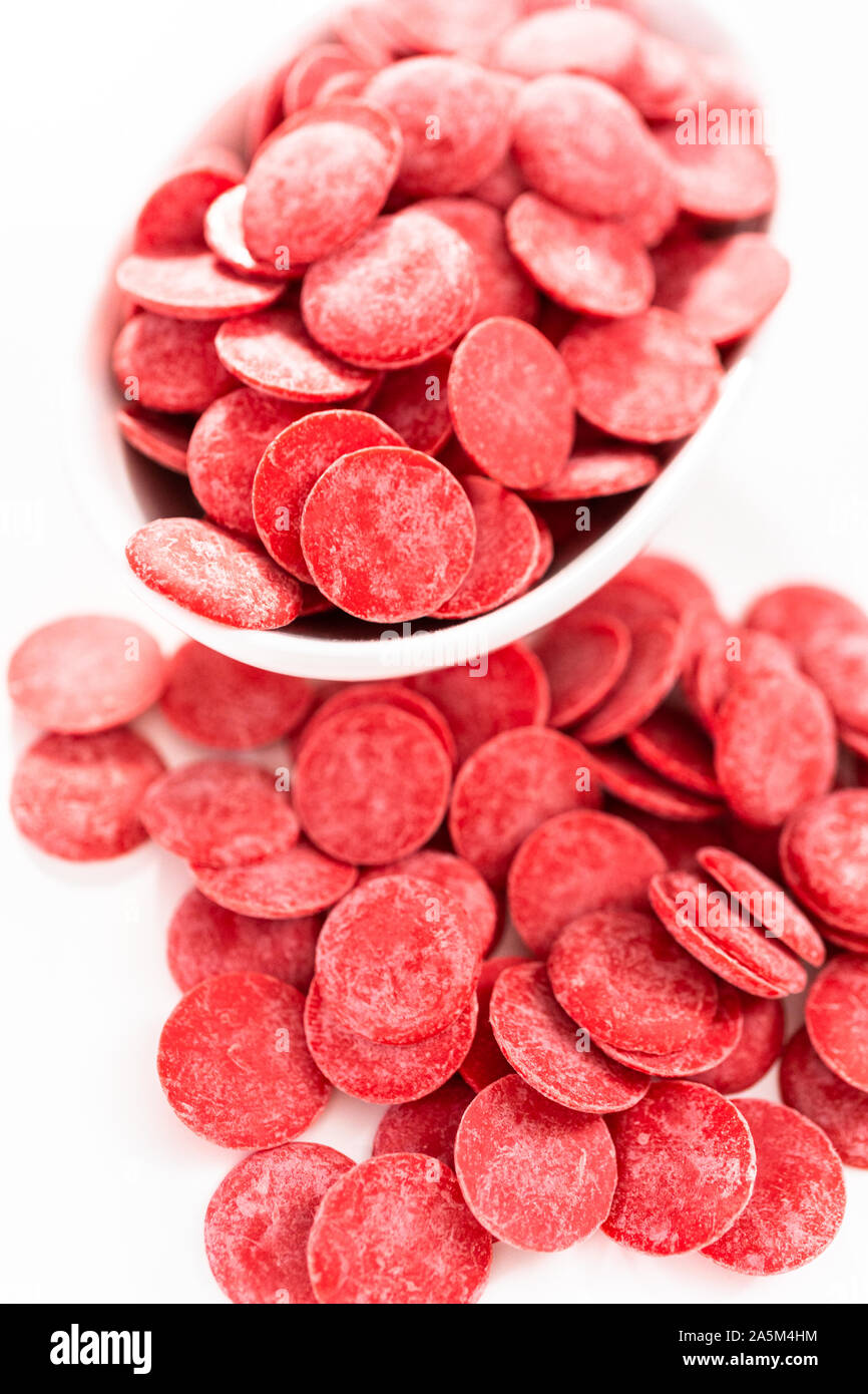 Red round chocolate chips for melting chocolate shapes on a white ...