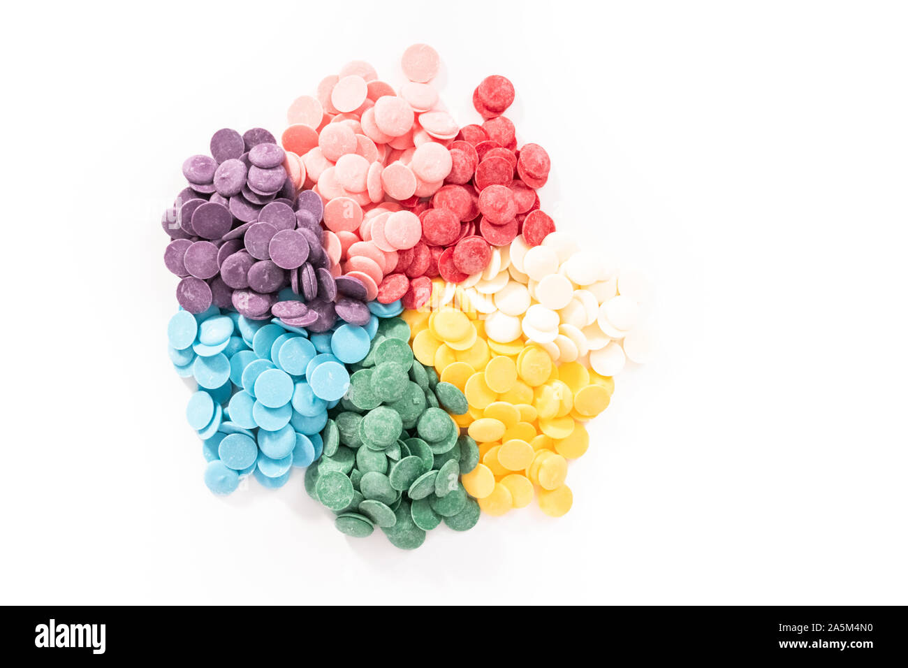 Flat lay. Pink round chocolate chips for melting chocolate shapes on a ...