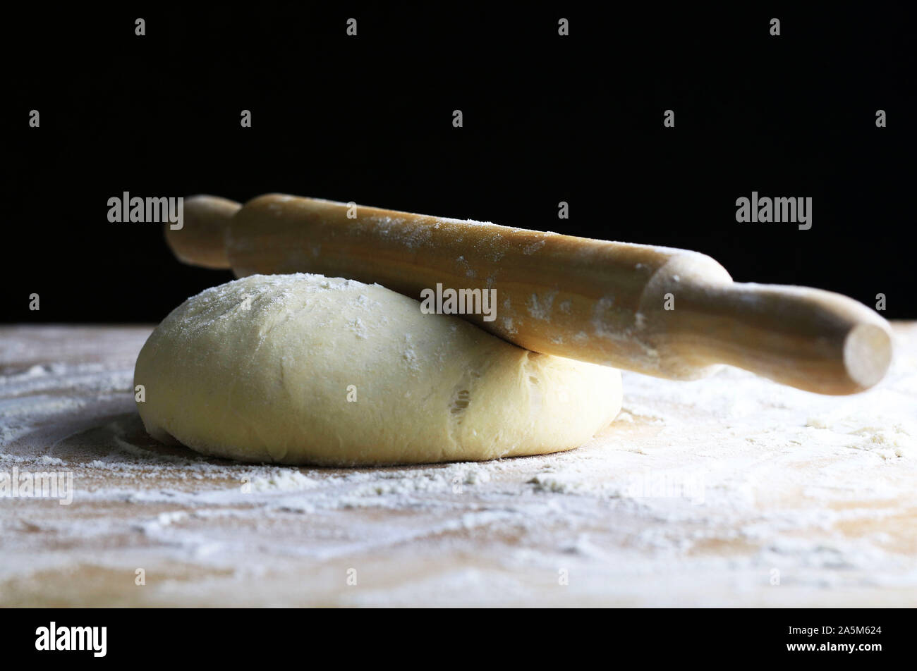 Fresh pasta ready for cooking with a rolling pin on a floured wooden ...