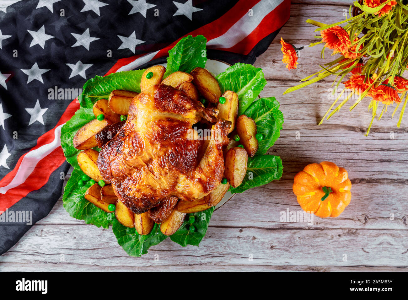 Thanksgiving celebration dinner with golden roast chicken and USA flag ...