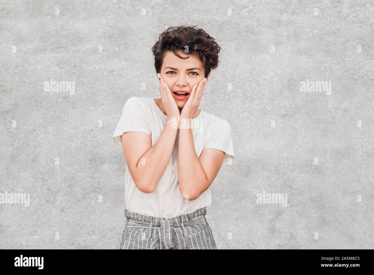 Charming young woman with creative hairstyle is posing with ...