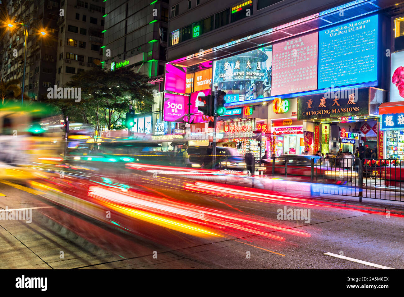 Traffic streaks down Nathan Road past ChungKing Mansions in Tsim Sha Tsui, Kowloon, Hong Kong ...