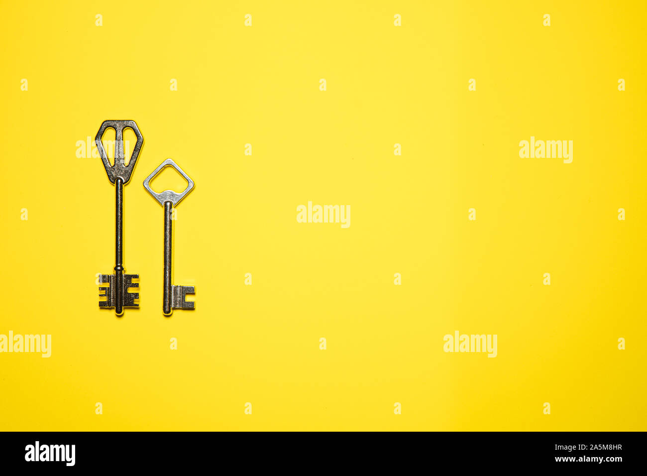 Keys on yellow background. Minimal creative style Stock Photo - Alamy