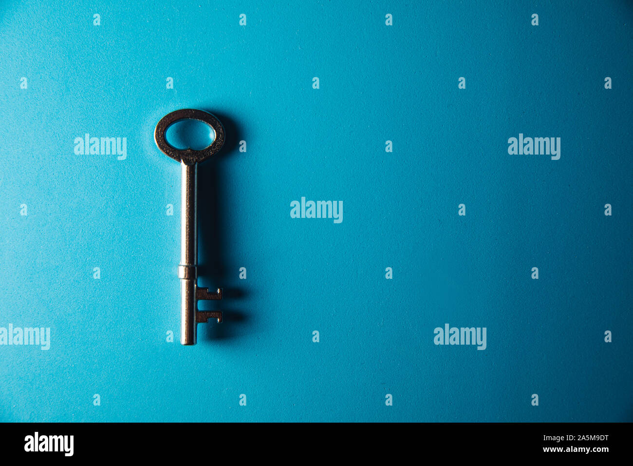 Key on blue background. Minimal creative style Stock Photo - Alamy