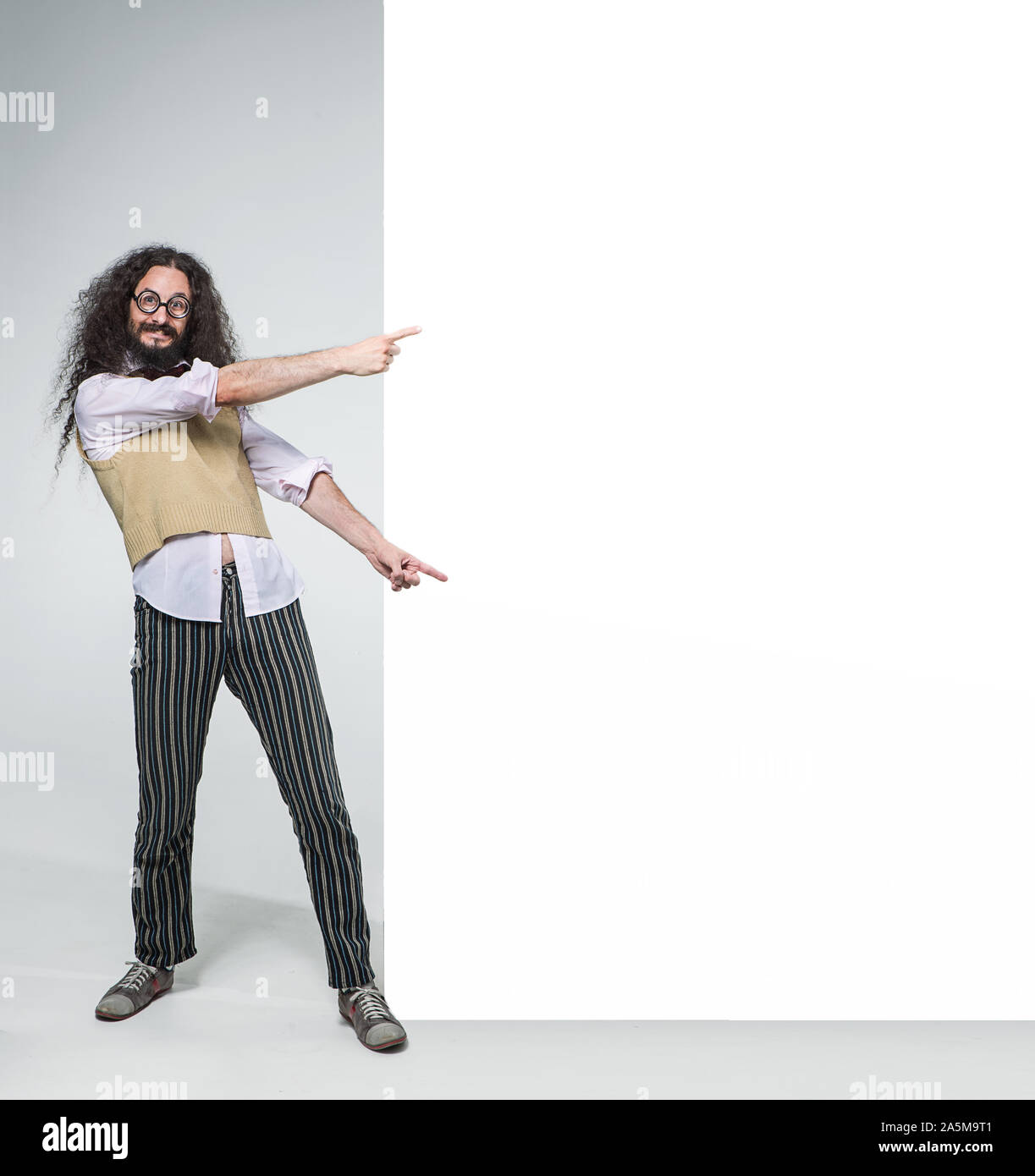 Eccentric guy pointing on the commercial, empty board Stock Photo - Alamy