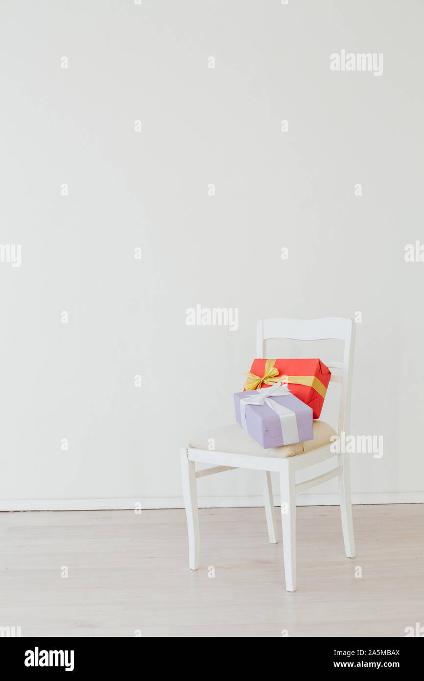 one chair with a gift in the interior of a white empty room Stock Photo ...