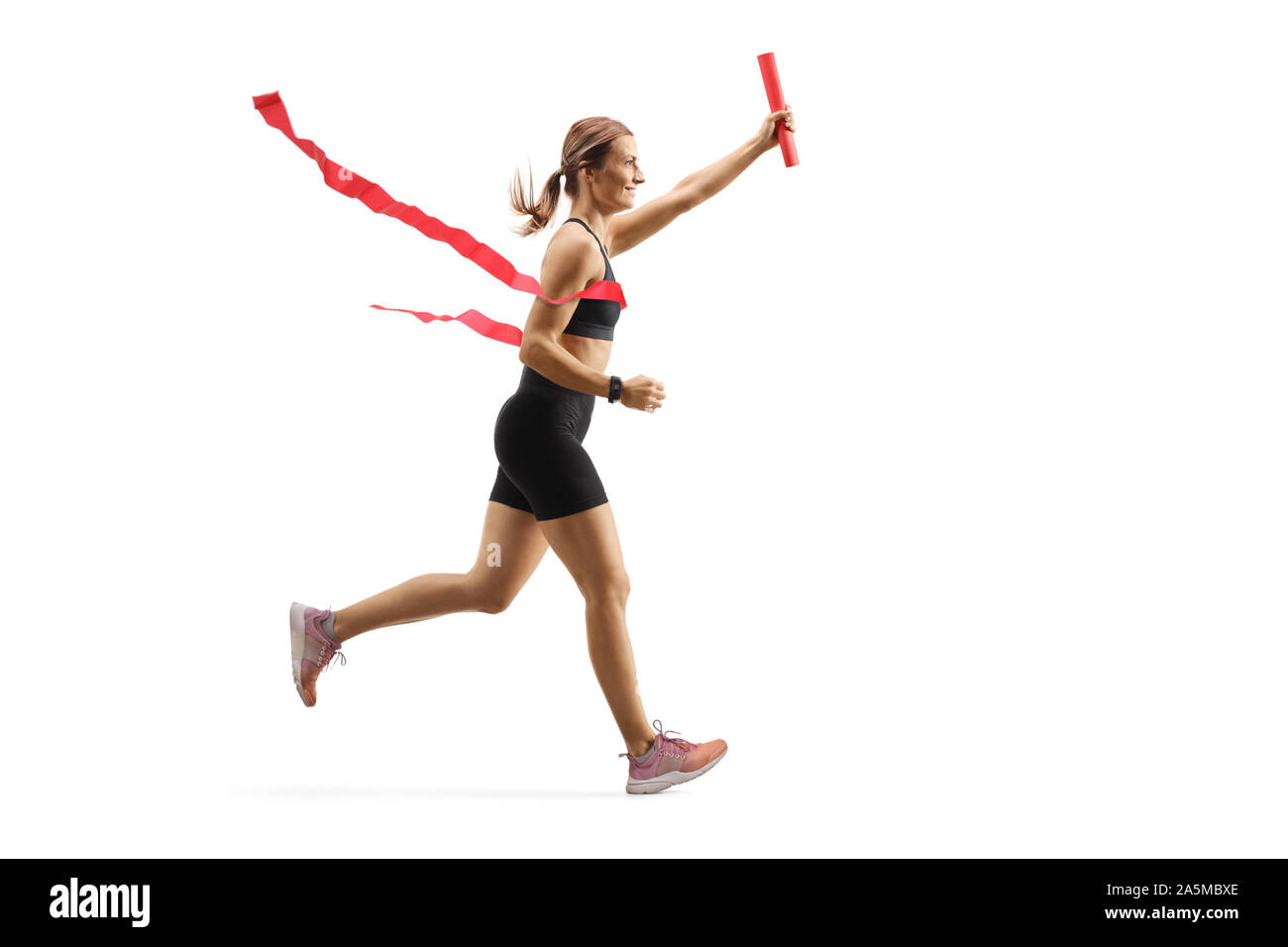 Full length profile shot of a woman finishing a relay race with a baton ...