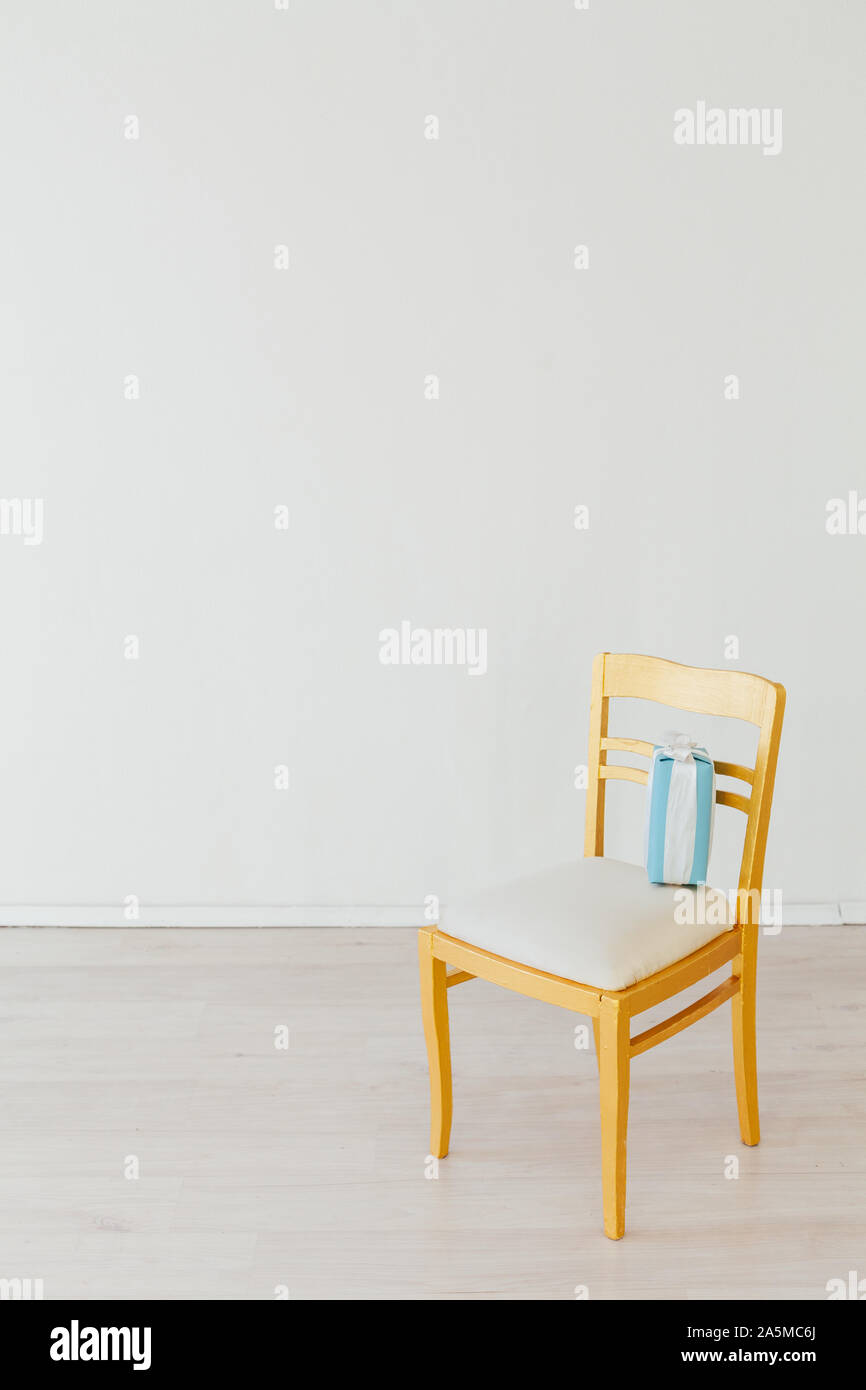 one chair with a gift in the interior of a white empty room Stock Photo ...