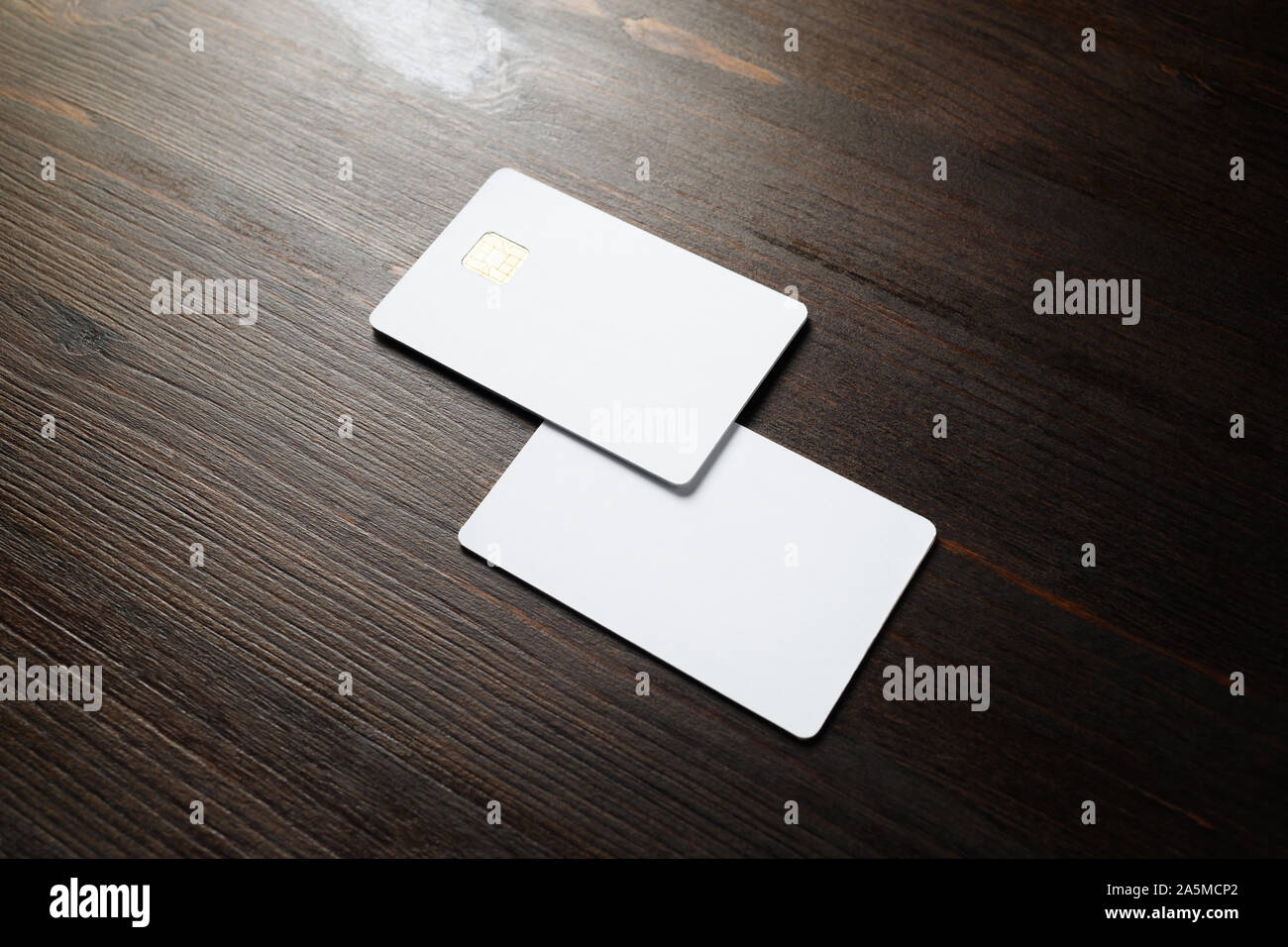 Photo of two blank credit cards on wood table background. White bank ...