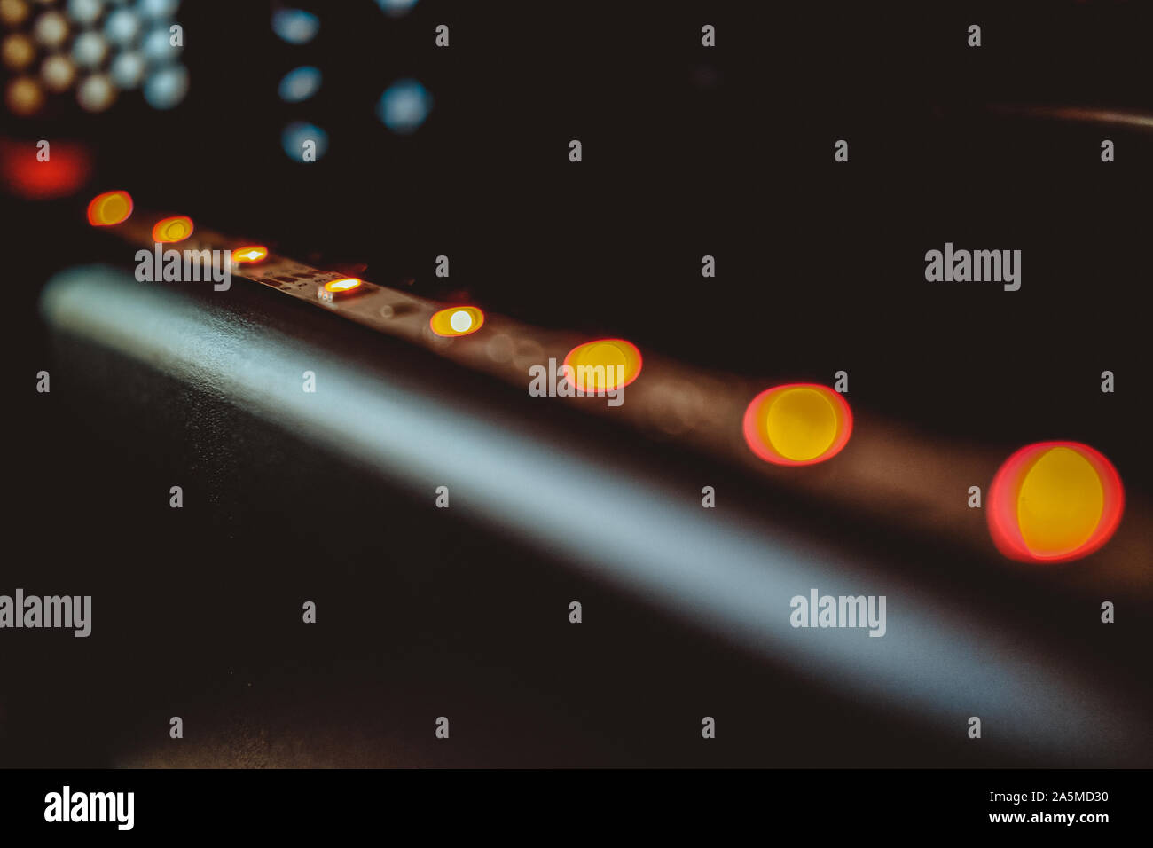 Line of yellow and orange led lights with the shadows of the ...