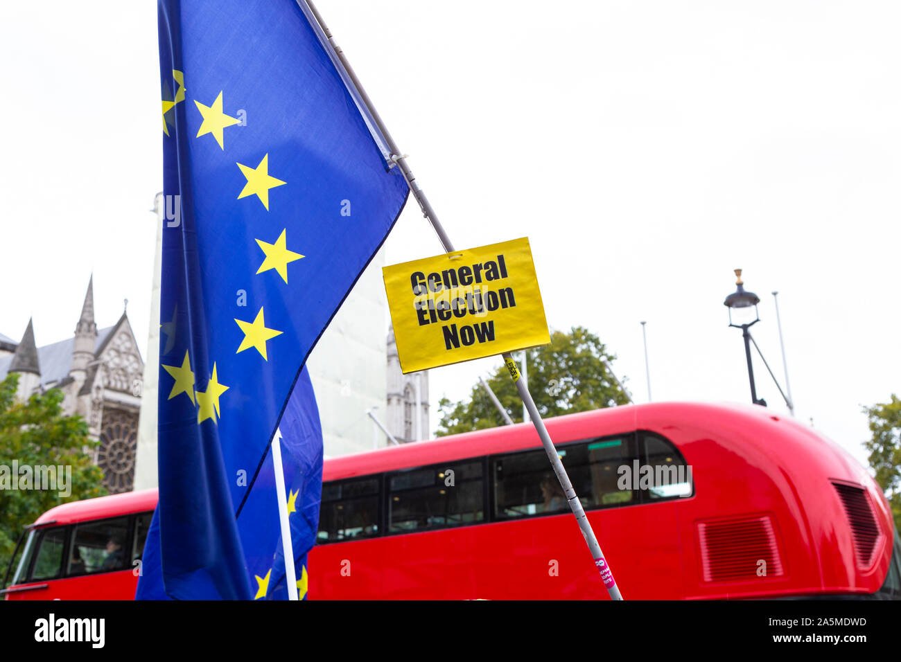EU flag, red bus and a general election sign outside parliament ...
