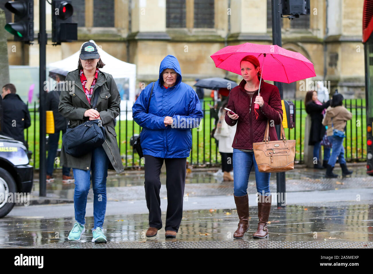 Woman sheltering from rain hi-res stock photography and images - Alamy