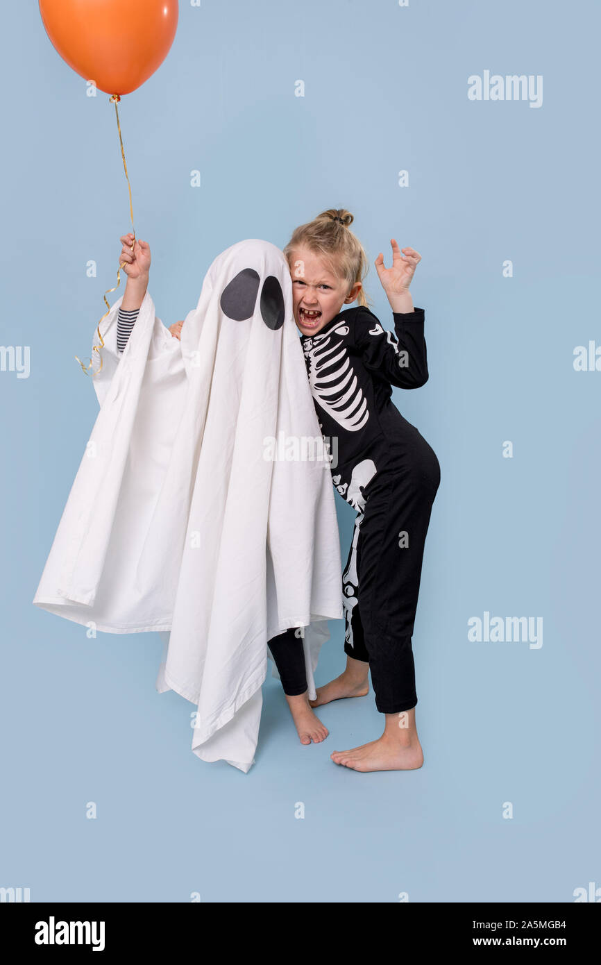 Kids in a ghost and skeleton costumes at Halloween have fun at studio ...