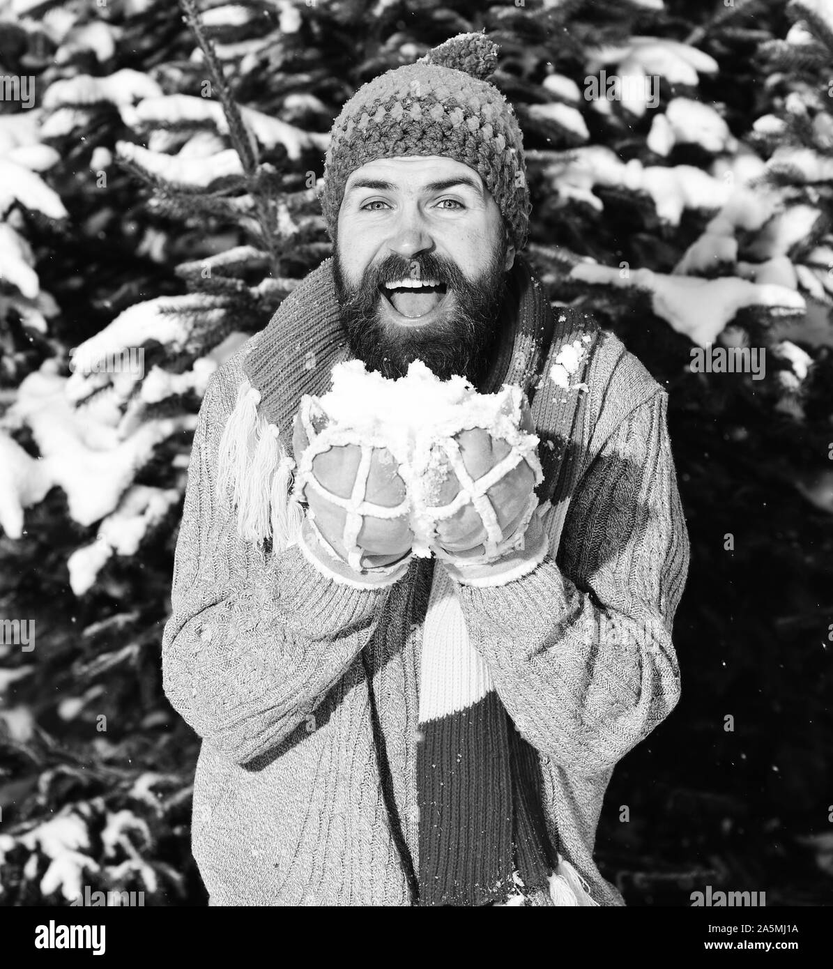 Happy winter vacation concept. Man wears knitted hat, scarf and gloves ...
