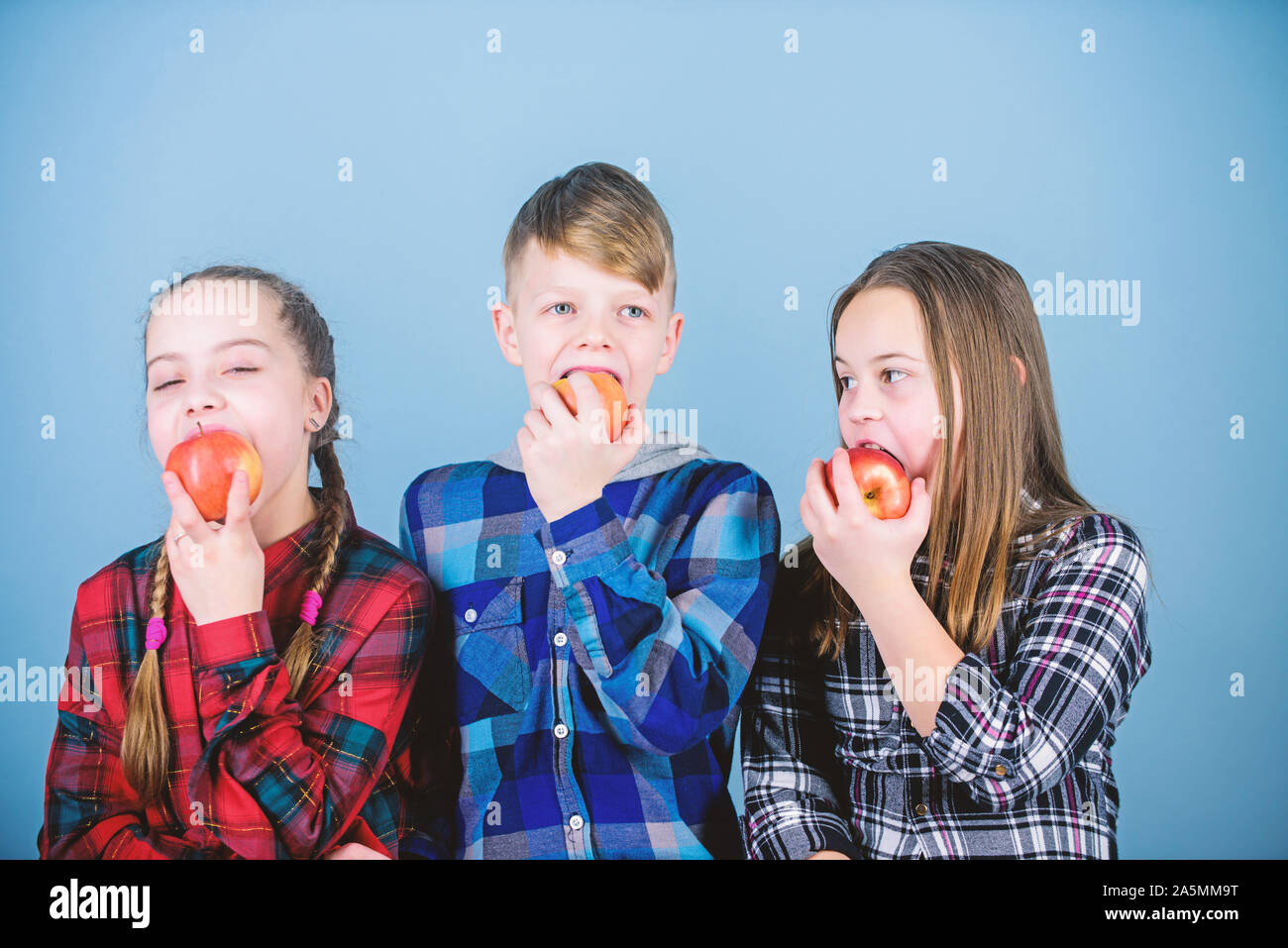 An apple a day keeps the doctor away. Little children biting red apples ...