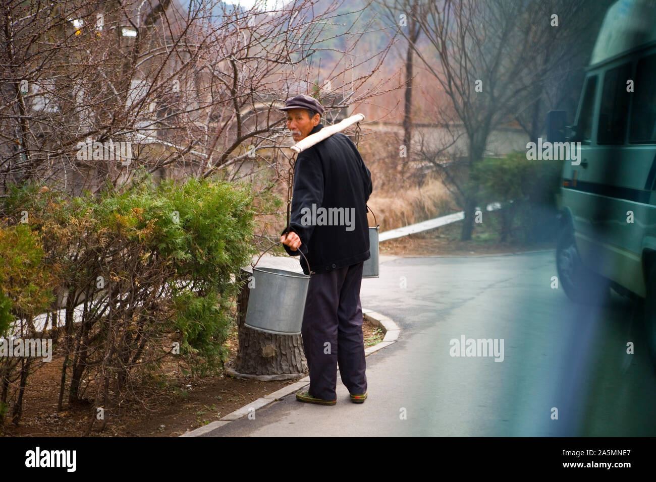 Man carrying large buckets of water Stock Photo - Alamy