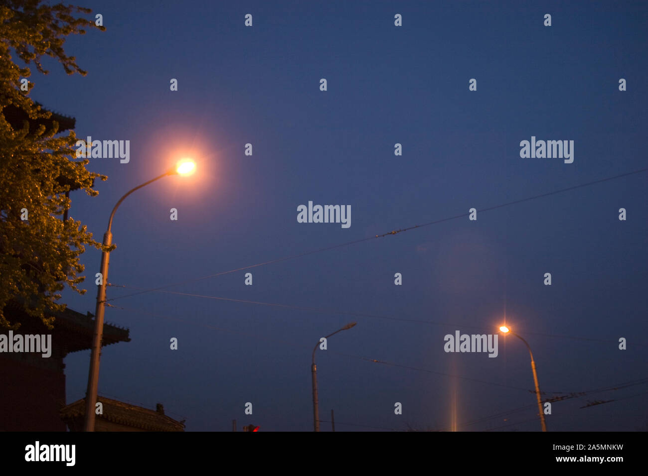 Illuminated street lights at dusk Stock Photo - Alamy