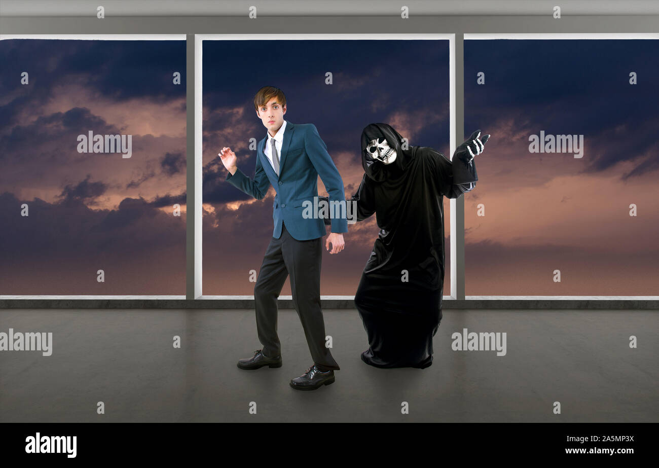 Man in a Halloween grim reaper ghost costume chasing, mocking and ...