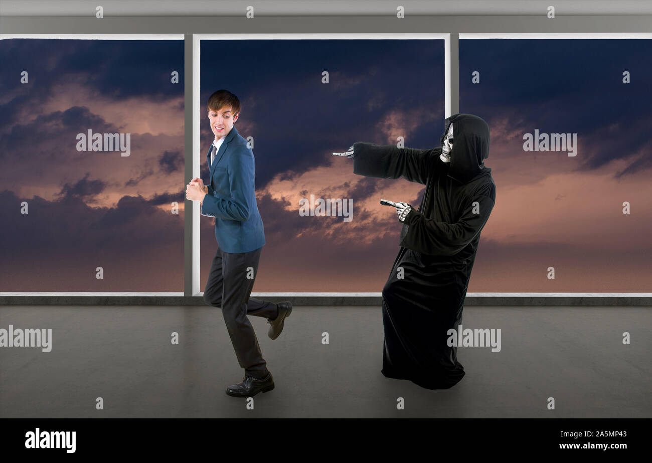 Man in a Halloween grim reaper ghost costume chasing, mocking and ...
