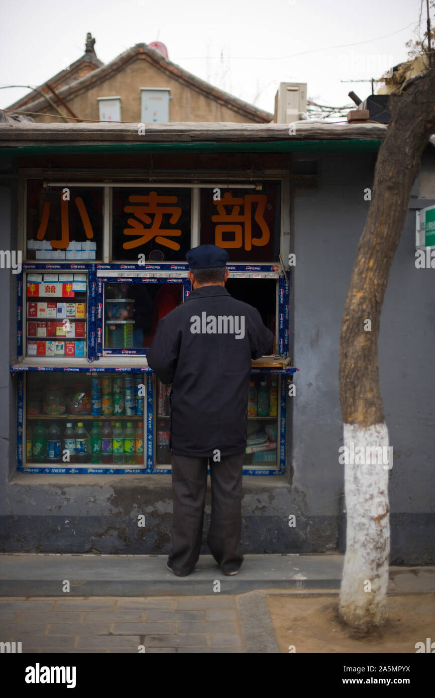 Male man standing outside a small shop on a street Stock Photo - Alamy