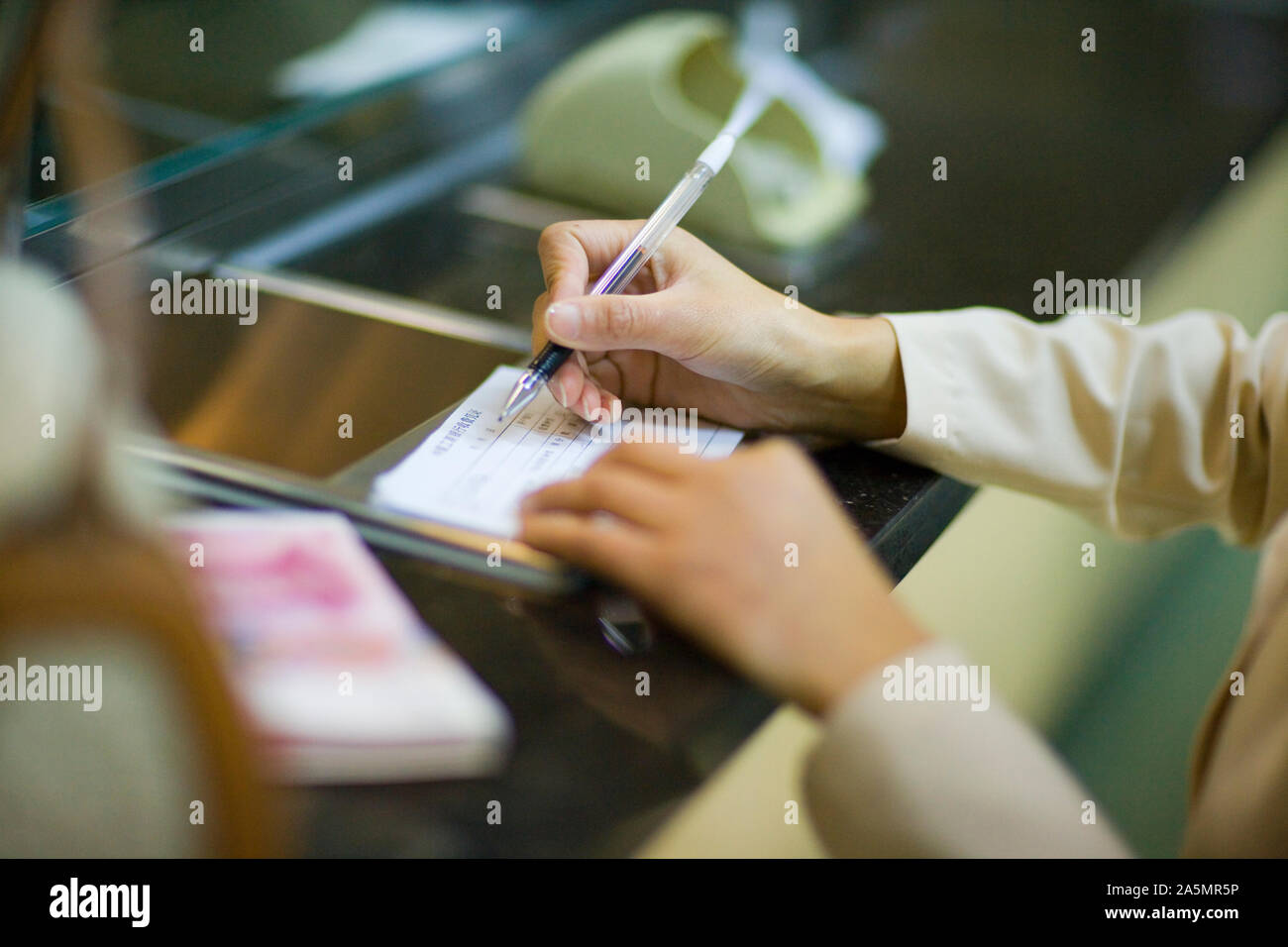 Women's hands writing in a check book Stock Photo - Alamy