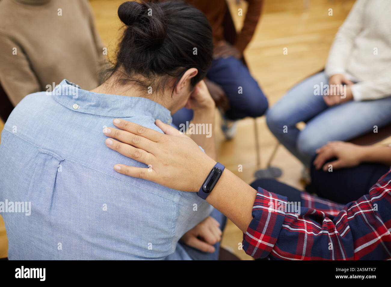 Back view of young man crying in support group with psychologist ...