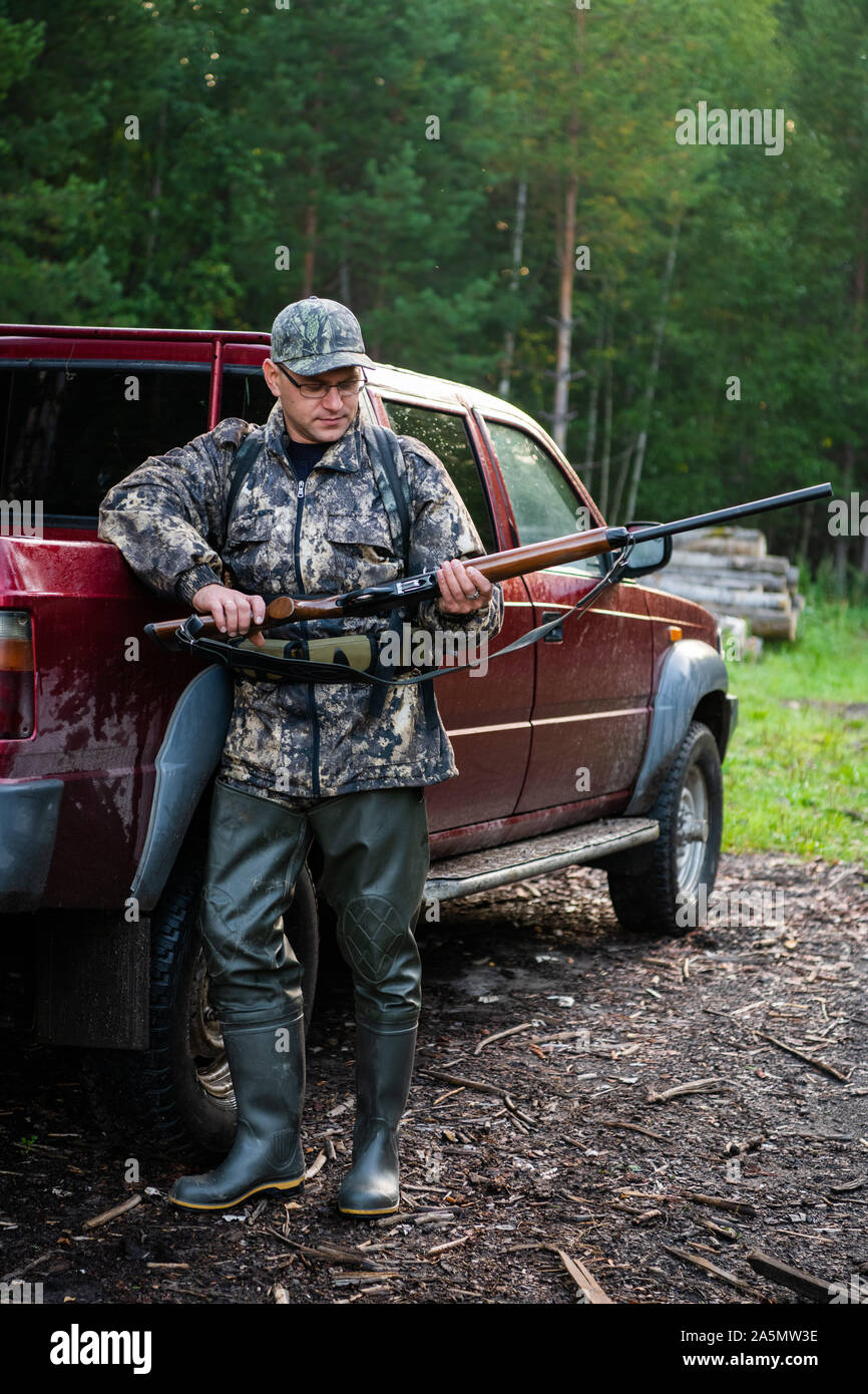 Hunter wearing glasses and camouflage with weapon shotgun at the ...