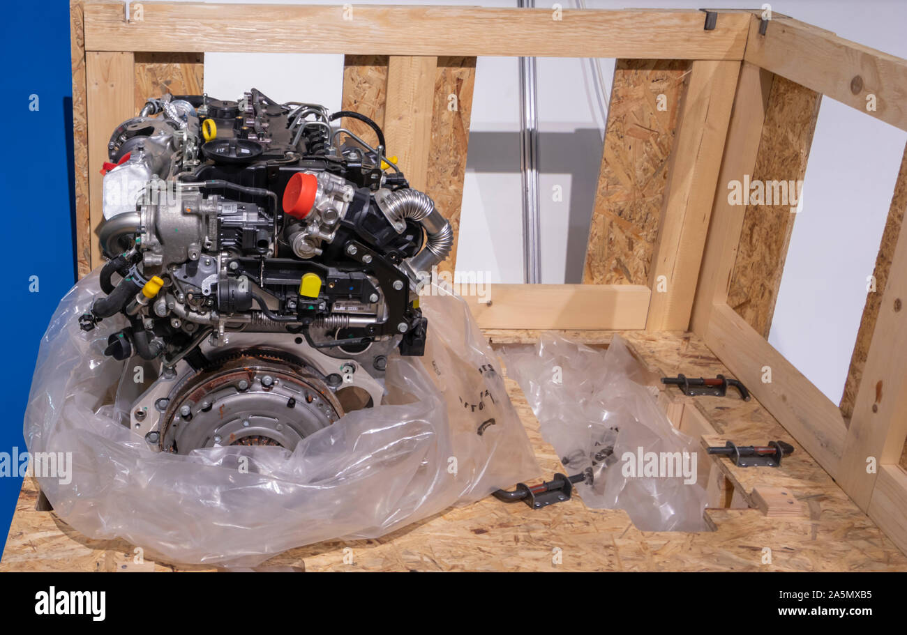 A new car engine block in a wooden shipping box, plastic wrap half ...