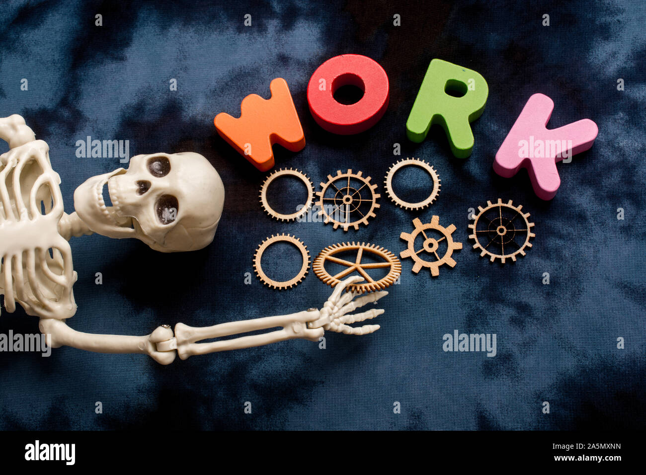 Artificial skeleton, work wording and wooden cogwheels as industry ...