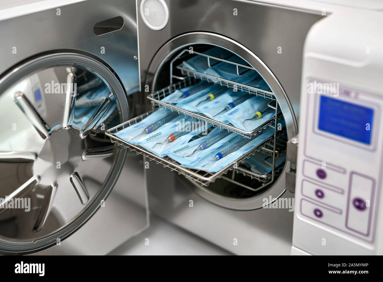 Opened autoclave sterilizer with many sealed dental probes. Closeup ...