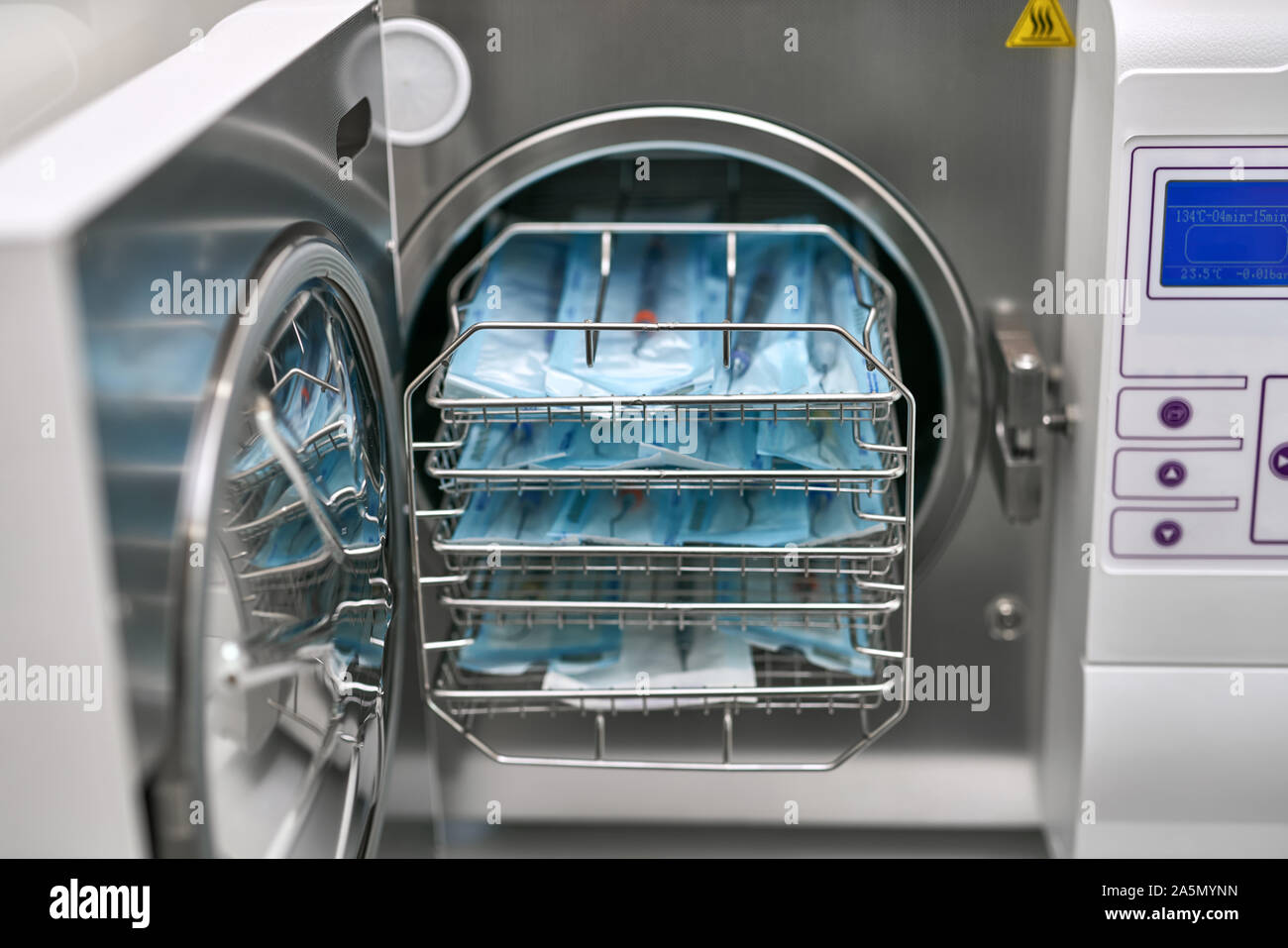 Many sealed dental probes inside an opened autoclave sterilizer ...