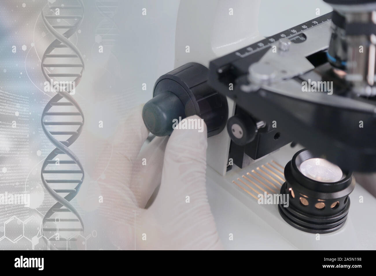 Young male male scientist looking through a microscope in a laboratory ...