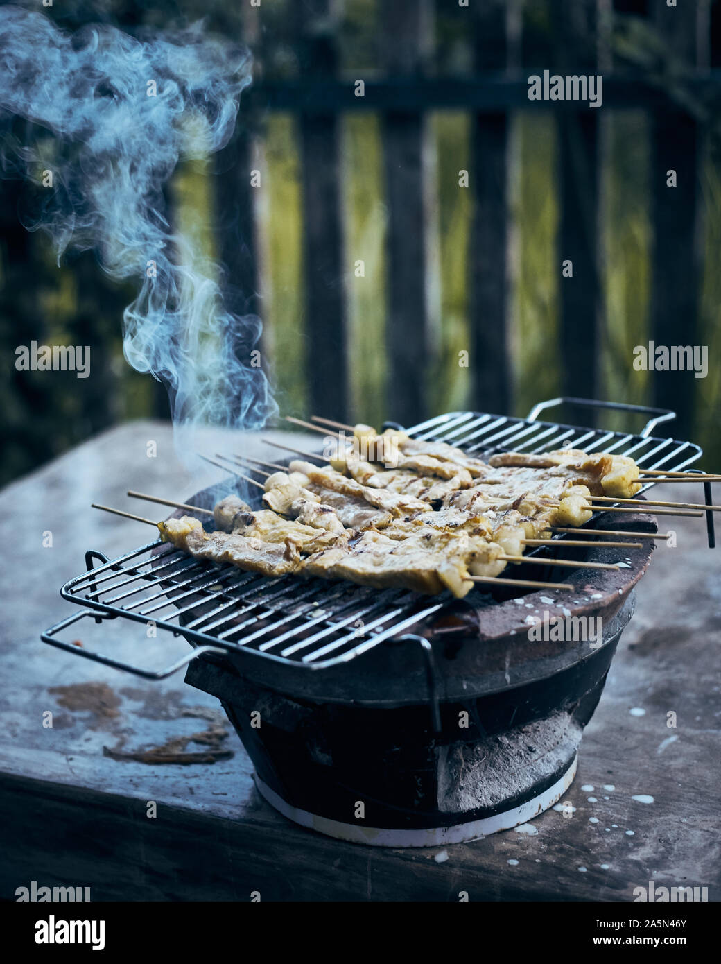 Pork satay grilling on stove Stock Photo - Alamy