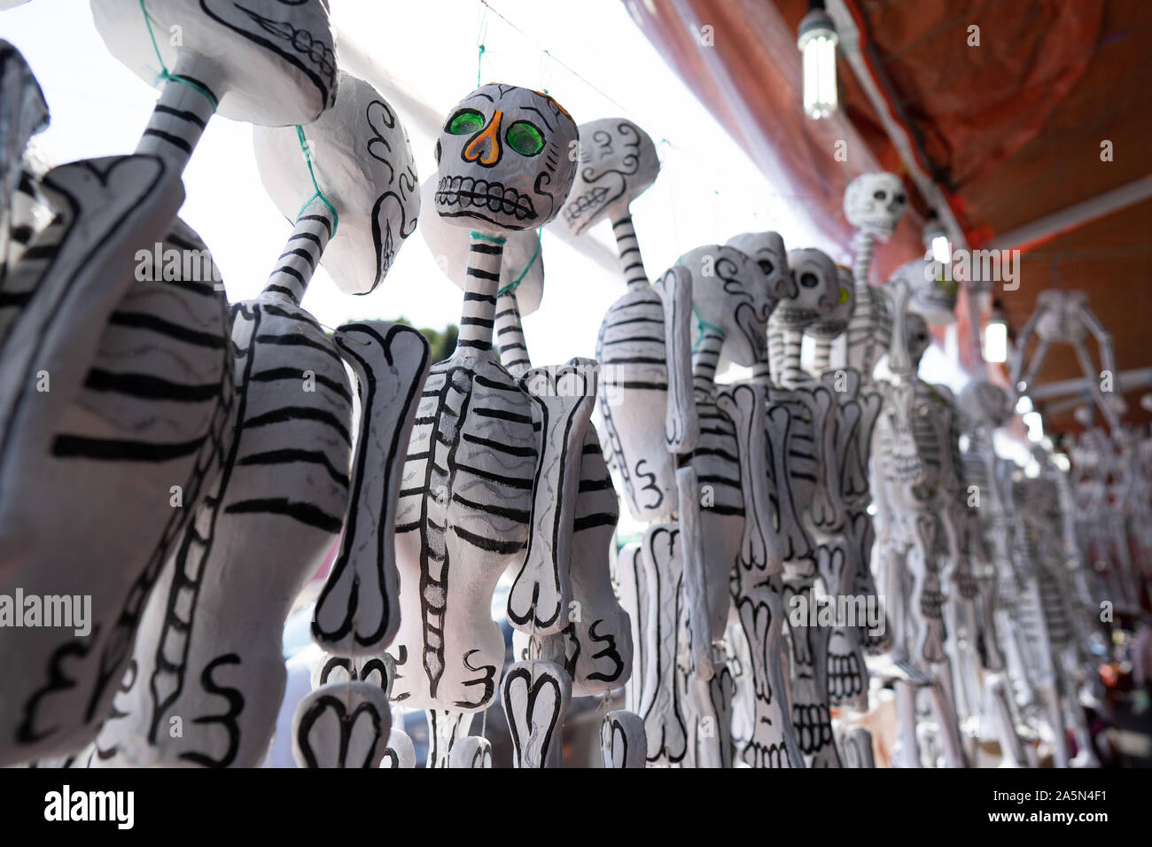 Day of the dead skeletons are being displayed at a market stall in ...