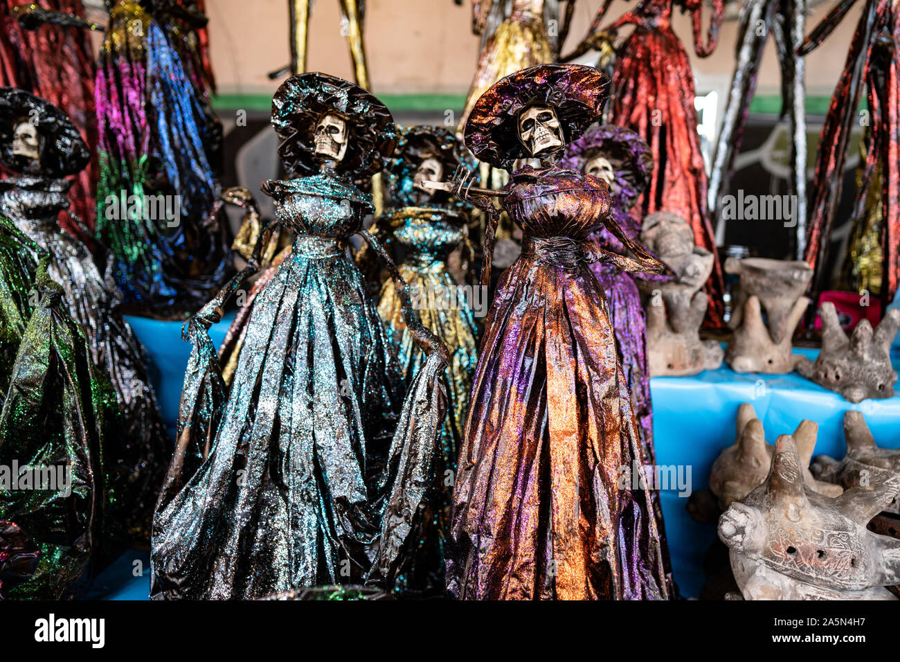 Day of the dead figurines are being displayed at a market stall in ...