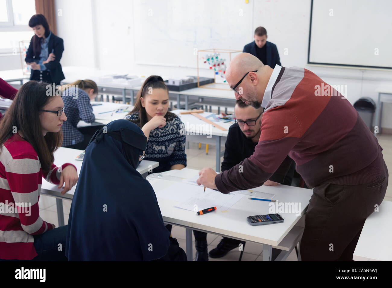 Male professor of architecture explain lesson to multiethnic students ...
